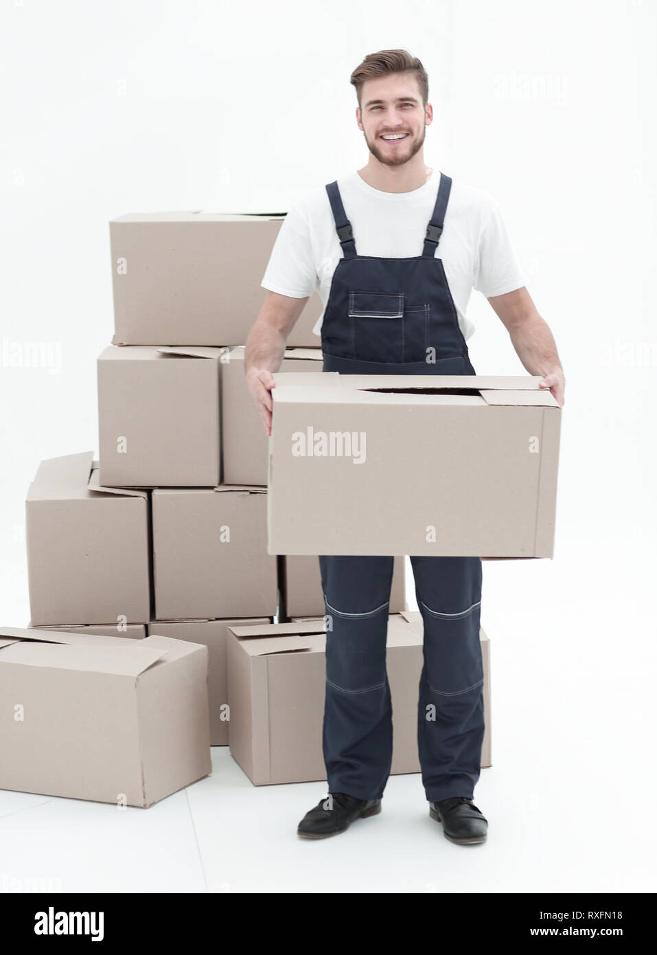 Young man carrying a box to the pile of boxes Stock Photo - Alamy
