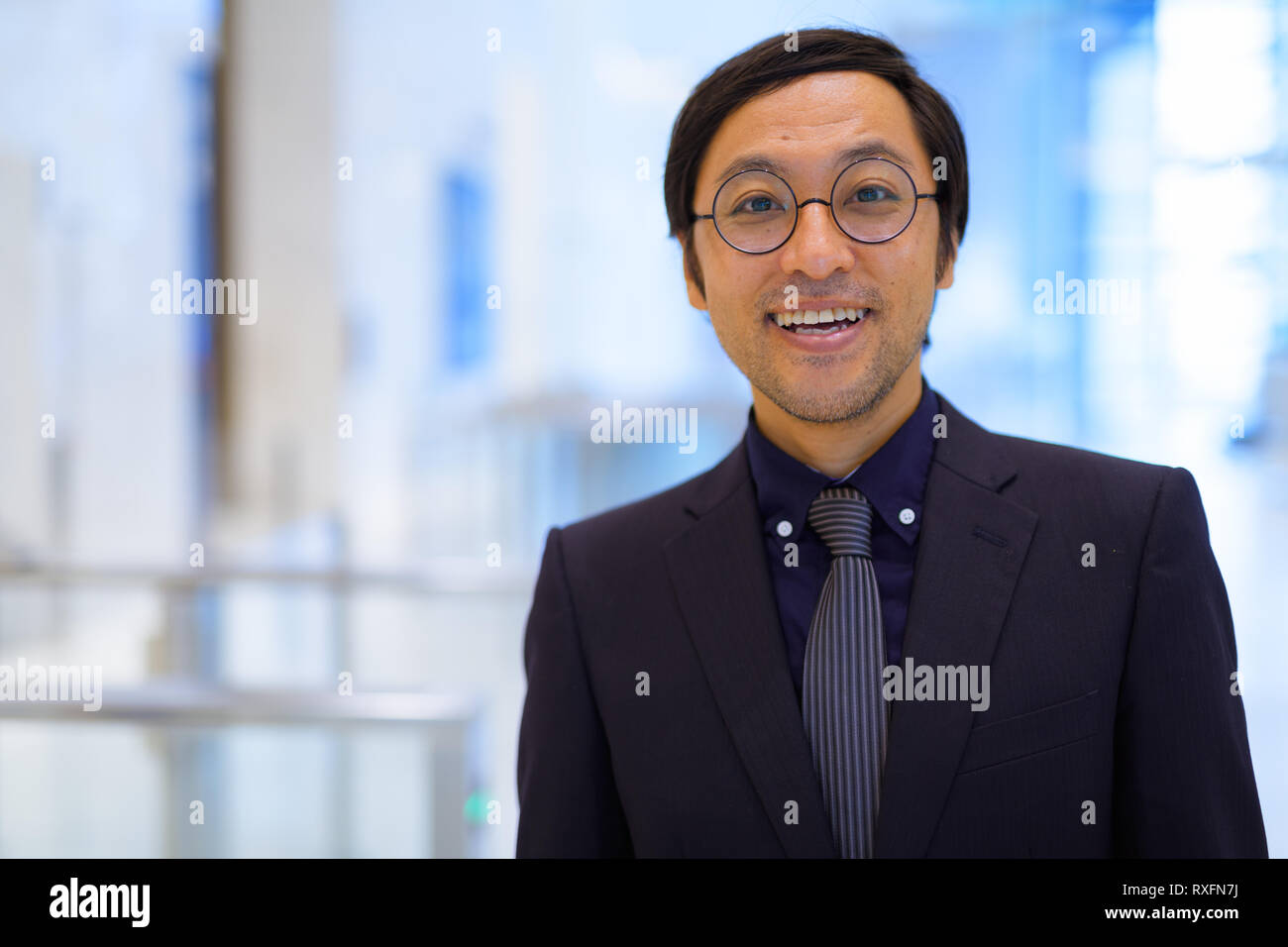 Face of happy Asian businessman smiling inside the office building ...