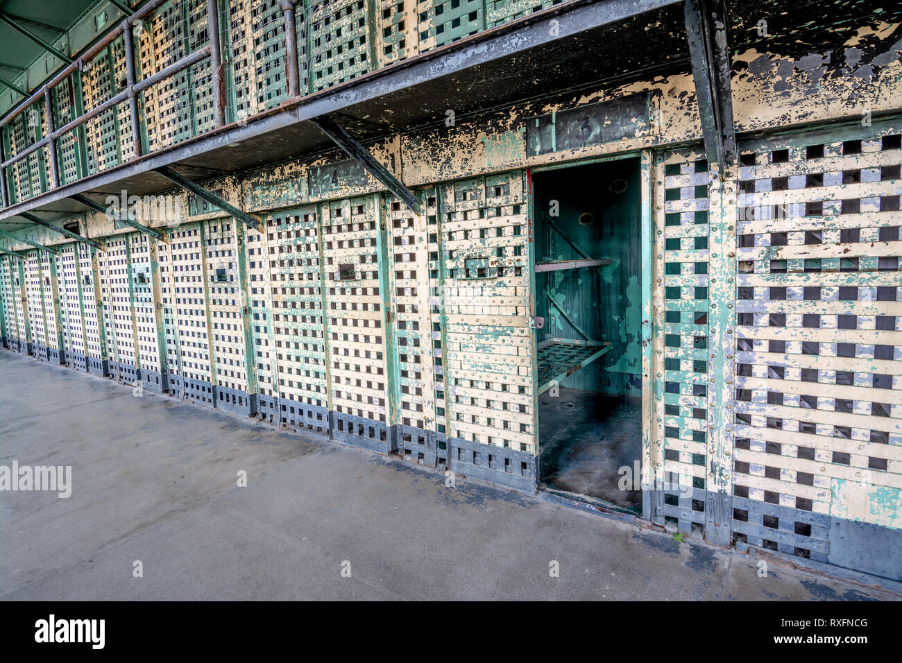 Old painted jail cell doors in a row with one of them open Stock Photo ...