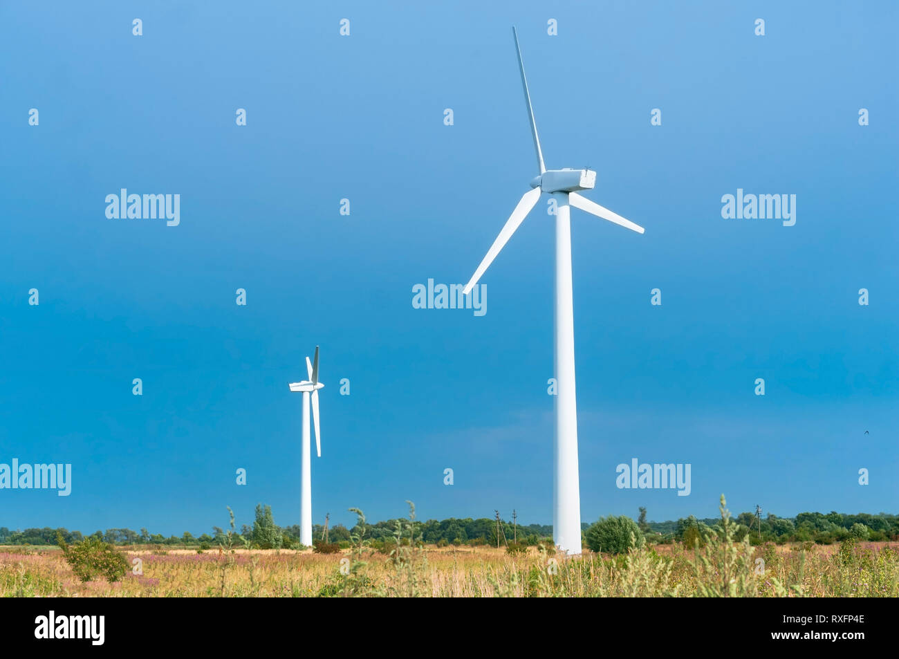 two wind turbines in the field, white wind power plants Stock Photo - Alamy