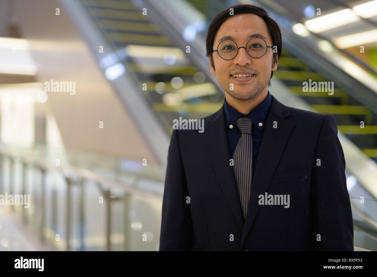 Face of happy Asian businessman smiling inside the office building ...