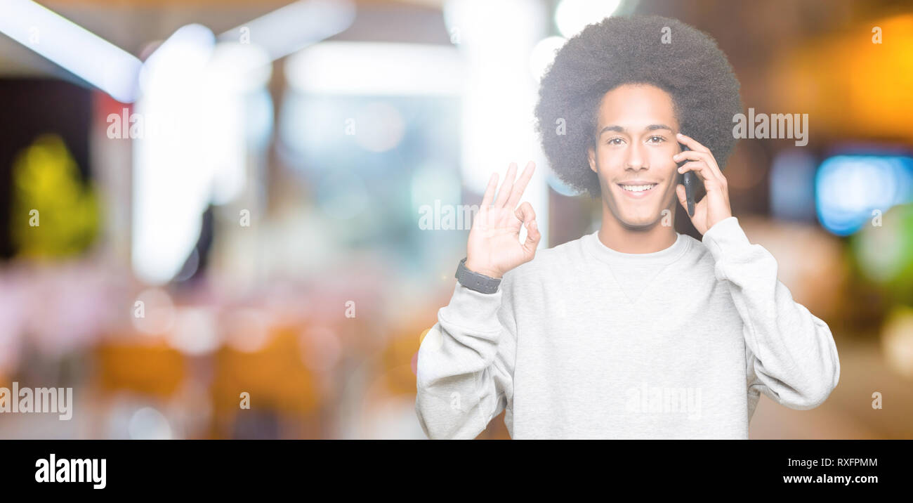 Young african american man with afro hair talking on smartphone doing ...