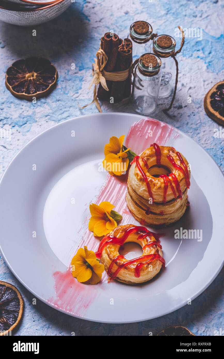 Vertical photo with several donuts made from puff pastry dough. Red ...