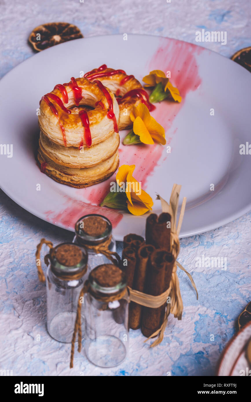 Vertical photo with several donuts made from puff pastry dough. Red ...