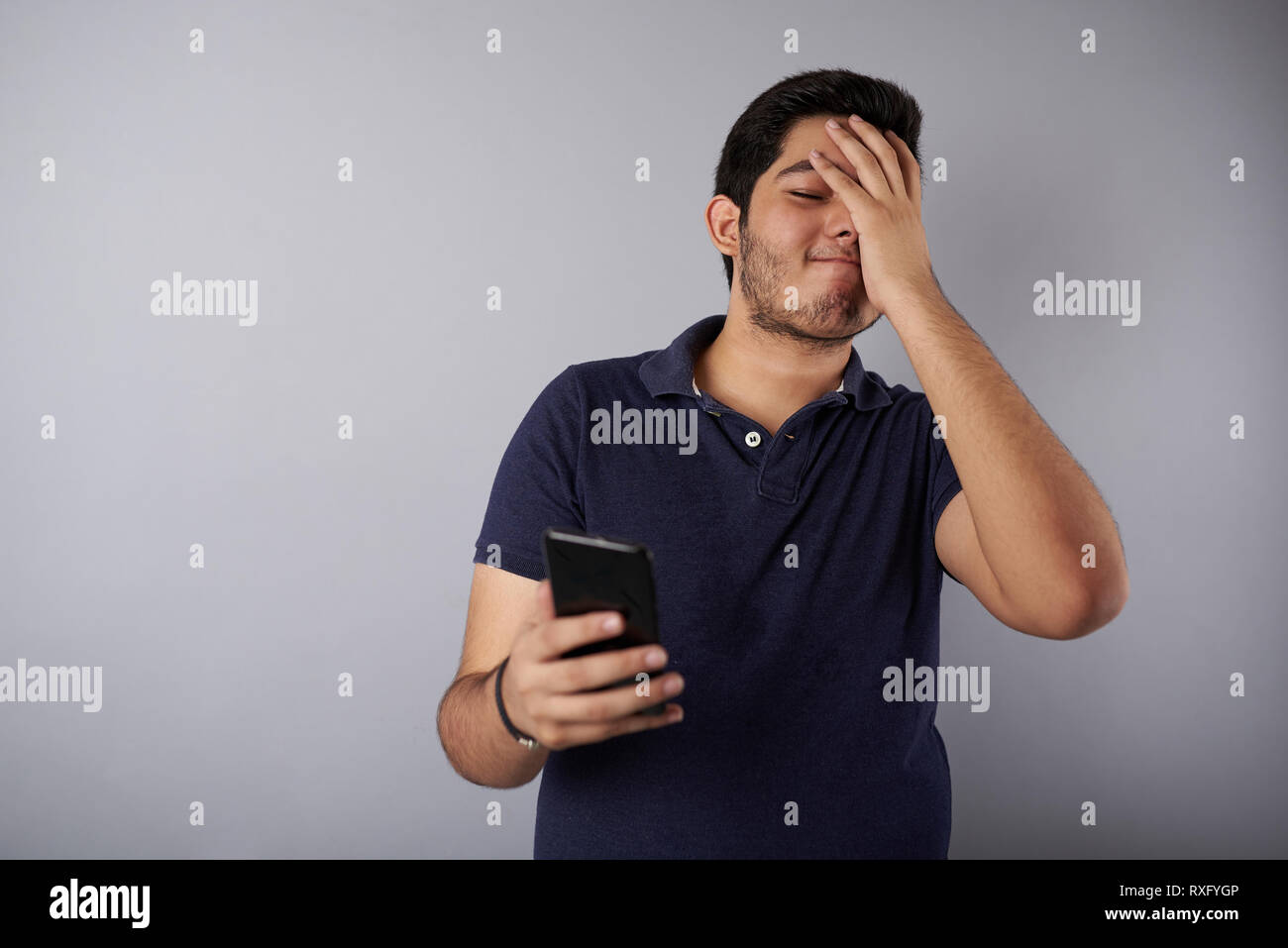 Laughing young man holding smartphone hi-res stock photography and ...