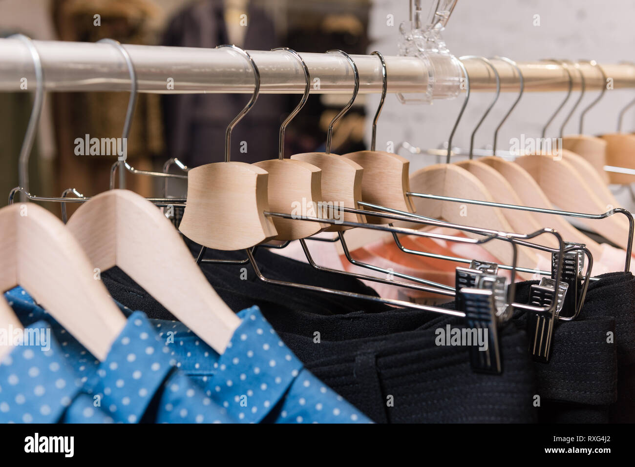 Wooden hangers with clothes in boutique shop Stock Photo - Alamy