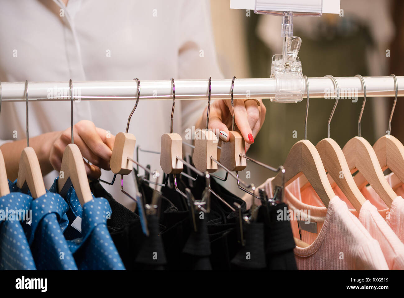 Female hands put clothes on stand with hangers Stock Photo - Alamy