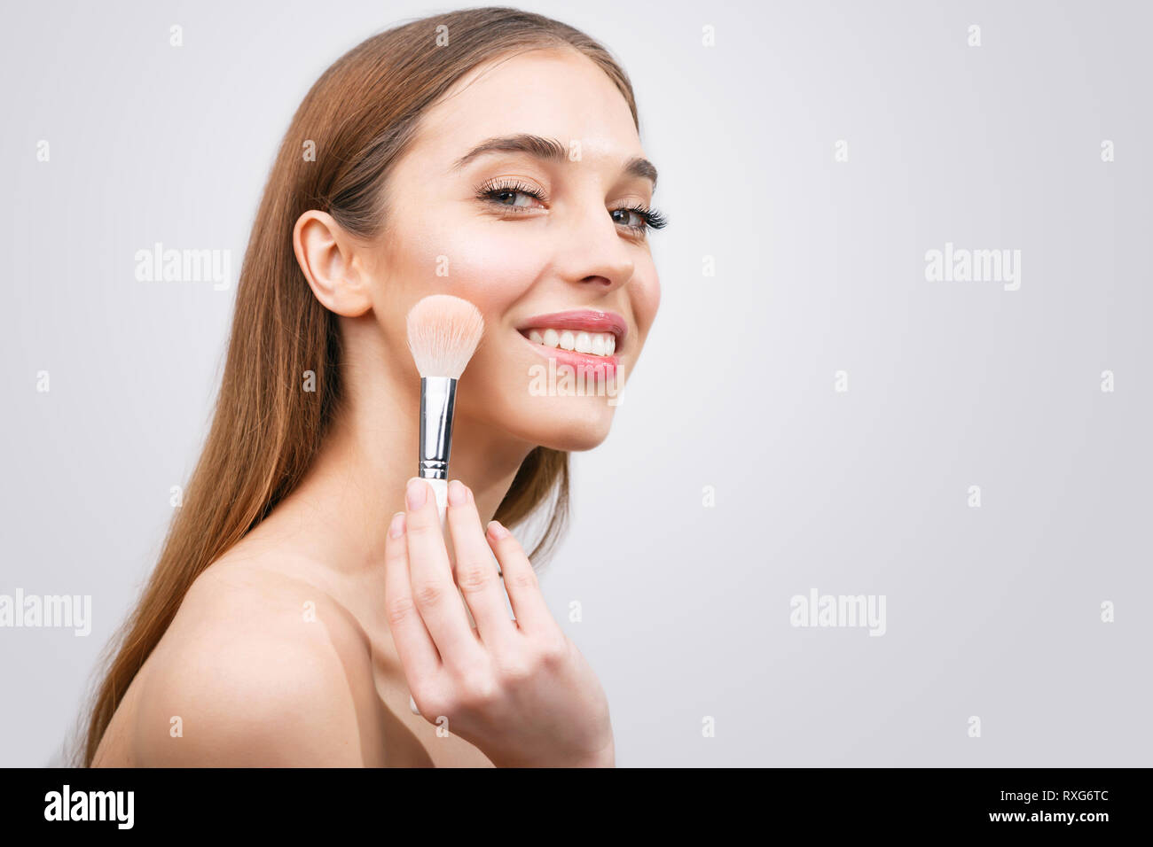 Portrait of attractive young pure woman applying blusher Stock Photo ...