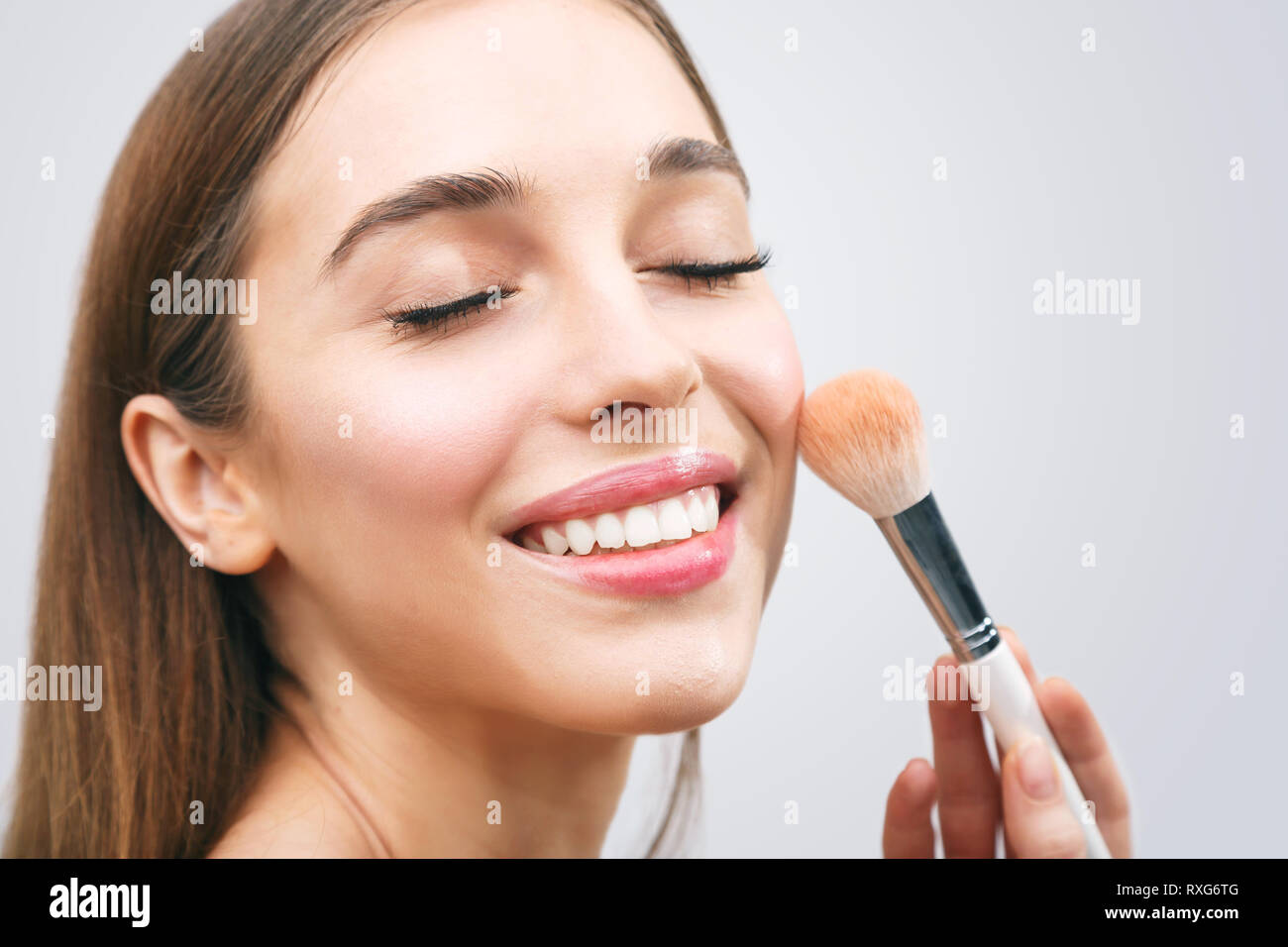 Portrait of beautiful woman applying cosmetic isolated on white Stock ...