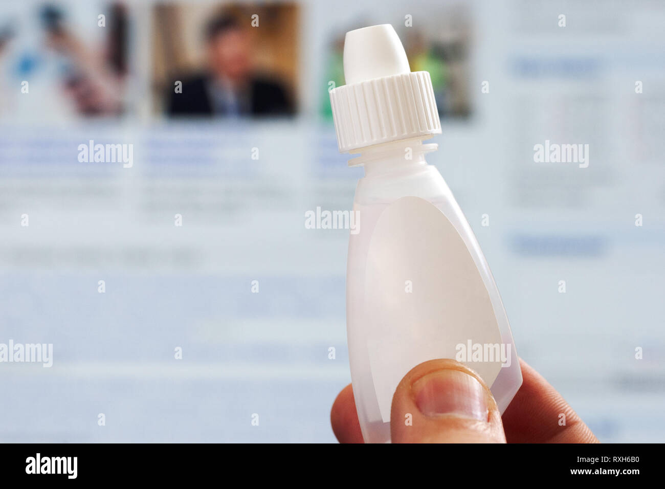 eye drops on the background of the monitor with news website. fatigue ...