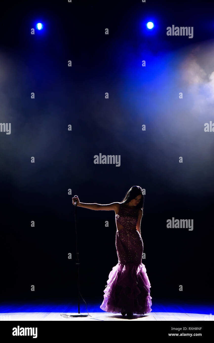 Female singer on the stage holding a microphone Stock Photo - Alamy