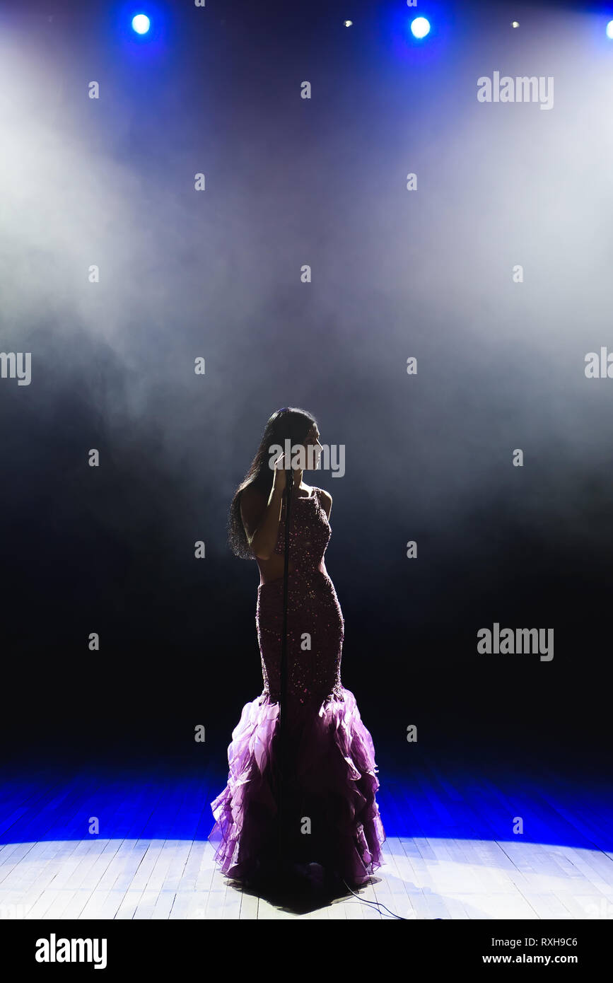 Female singer on the stage holding a microphone Stock Photo - Alamy