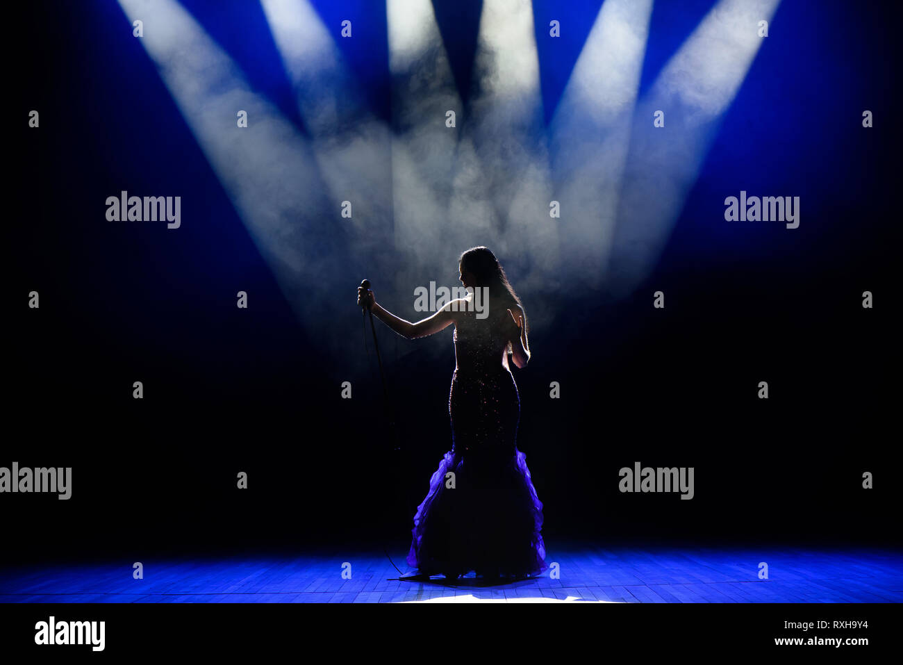 A young woman singer on stage during a concert Stock Photo - Alamy