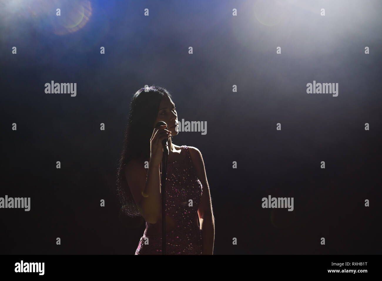 Portrait of beautiful singing woman on dark background Stock Photo - Alamy