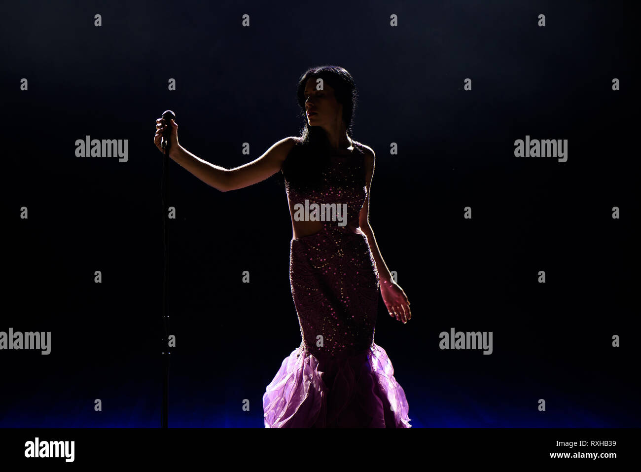 Female singer on the stage holding a microphone Stock Photo - Alamy