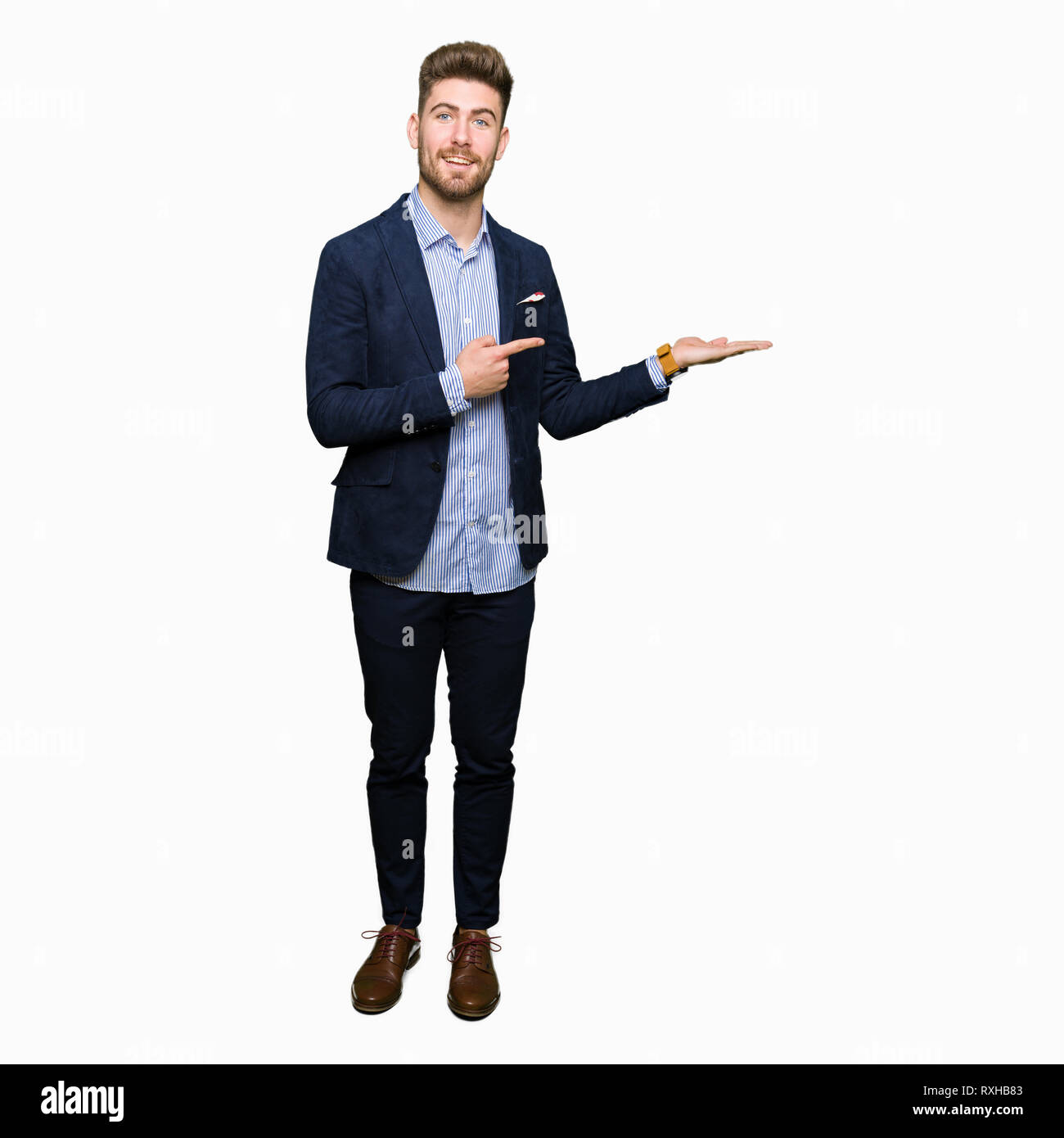 Young handsome bussines man amazed and smiling to the camera while ...