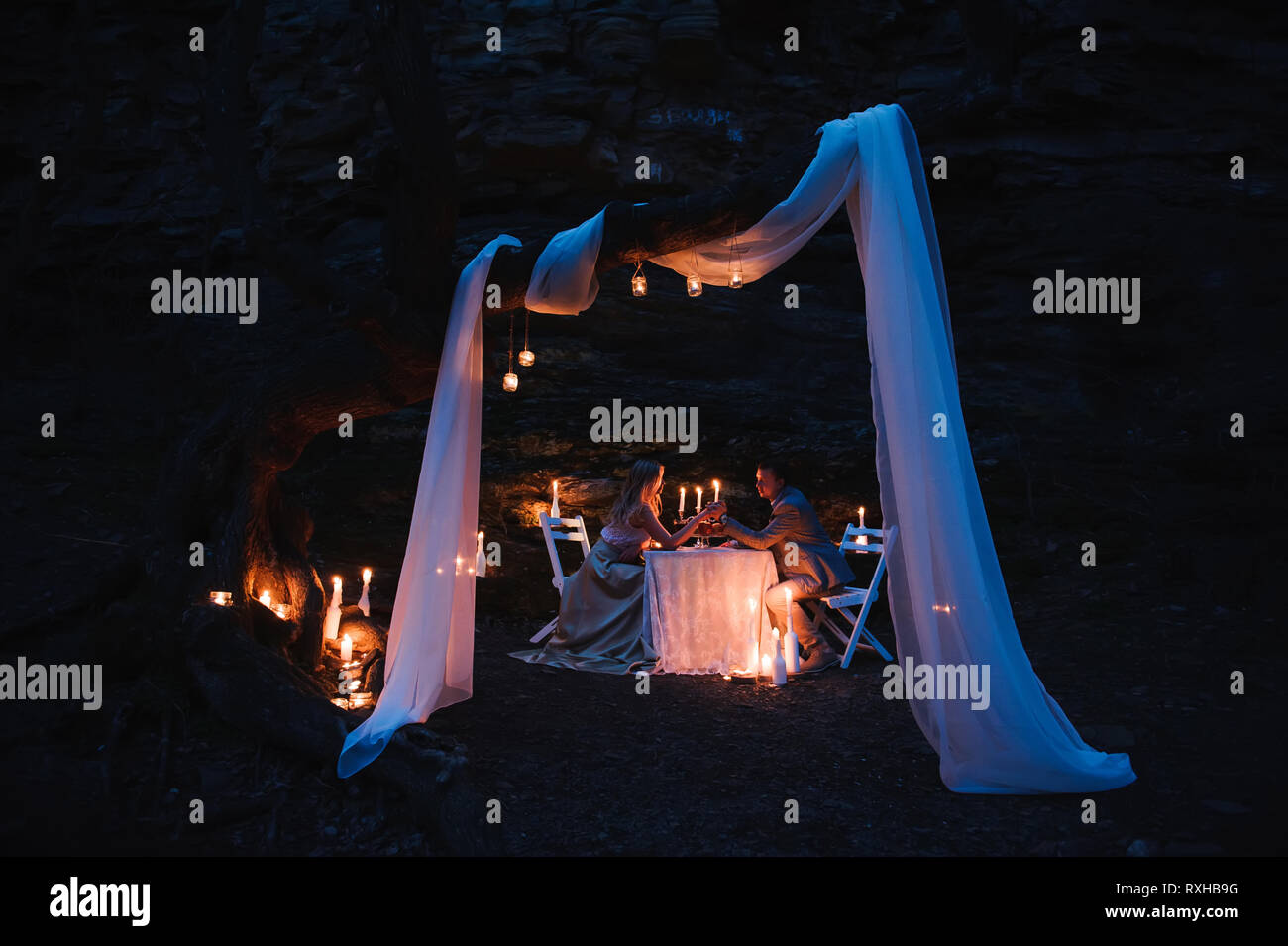 Romantic couple holding hands together over candlelight during romantic ...