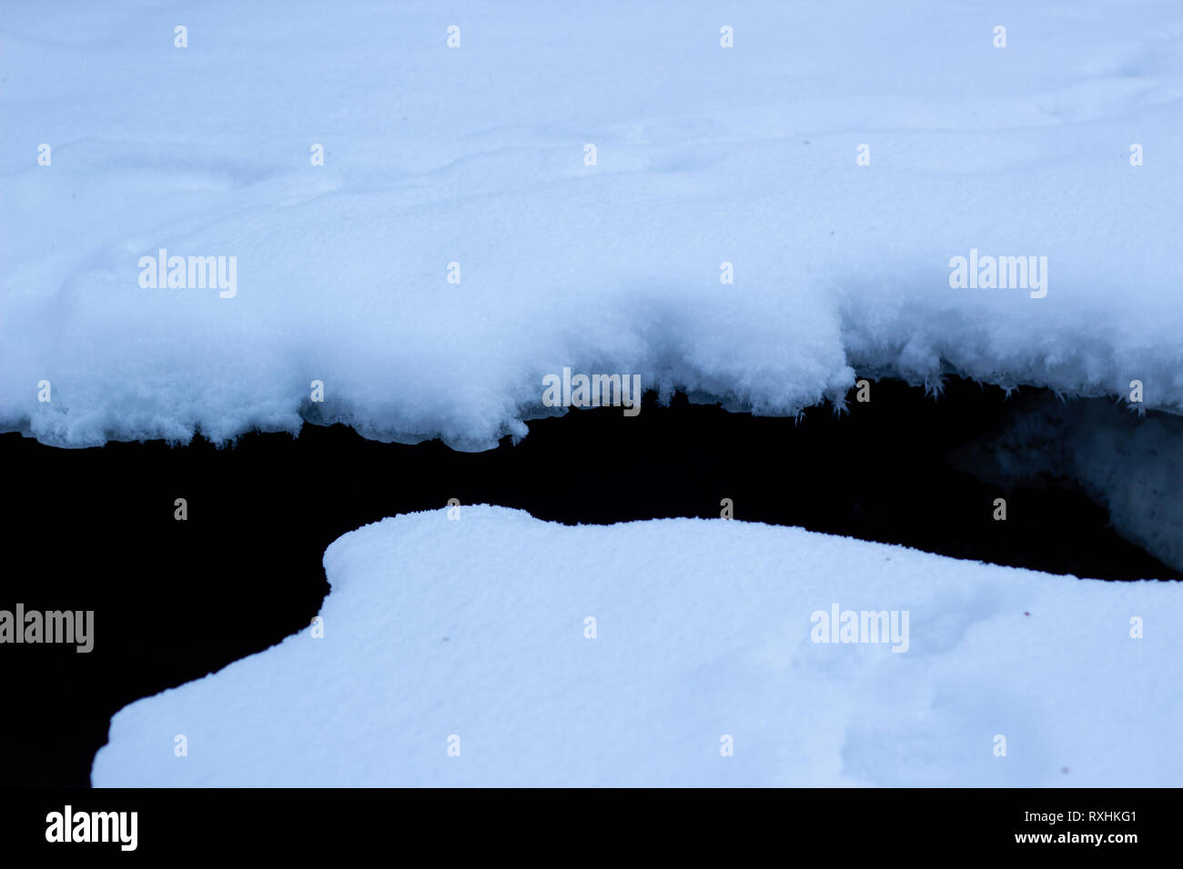 Crack in the snow and ice creating interesting shapes. River running ...