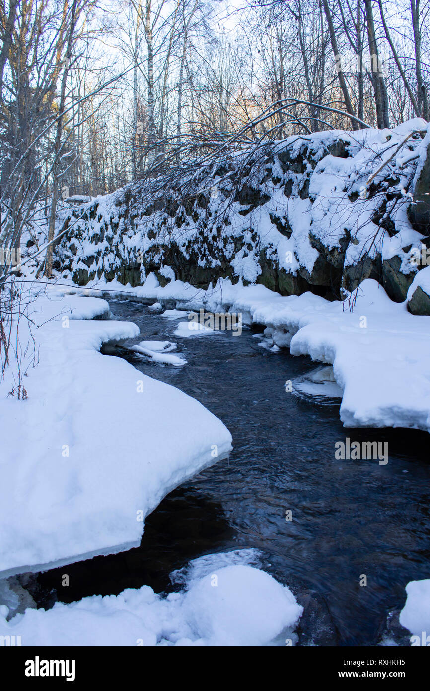River surrounded by ice and snow, and a wall of piled rocks in a ...