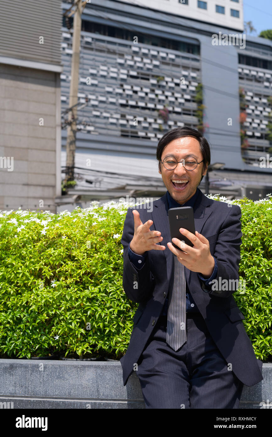 Happy Asian businessman vlogging with phone in the city Stock Photo - Alamy