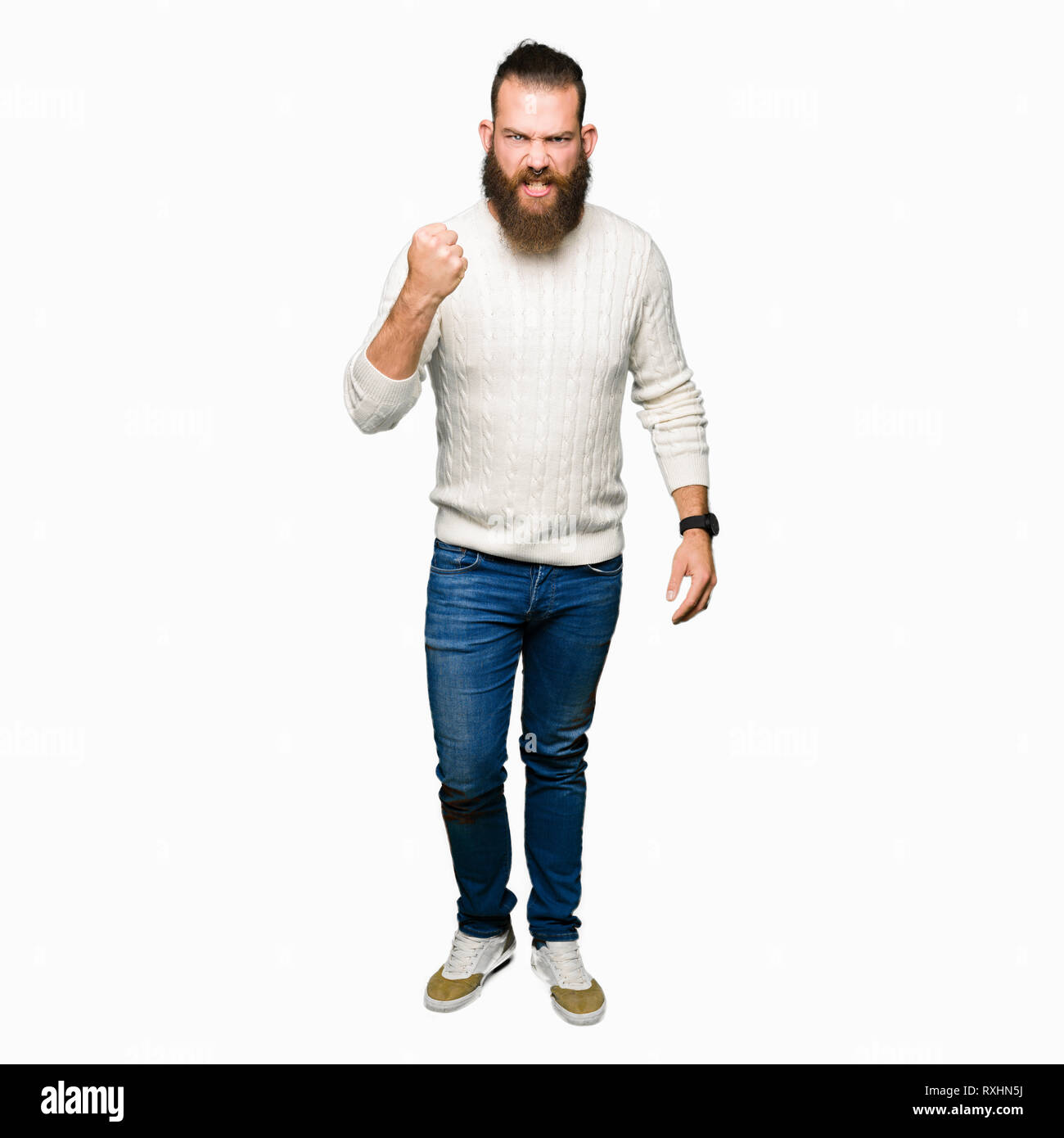 Young hipster man wearing winter sweater angry and mad raising fist ...
