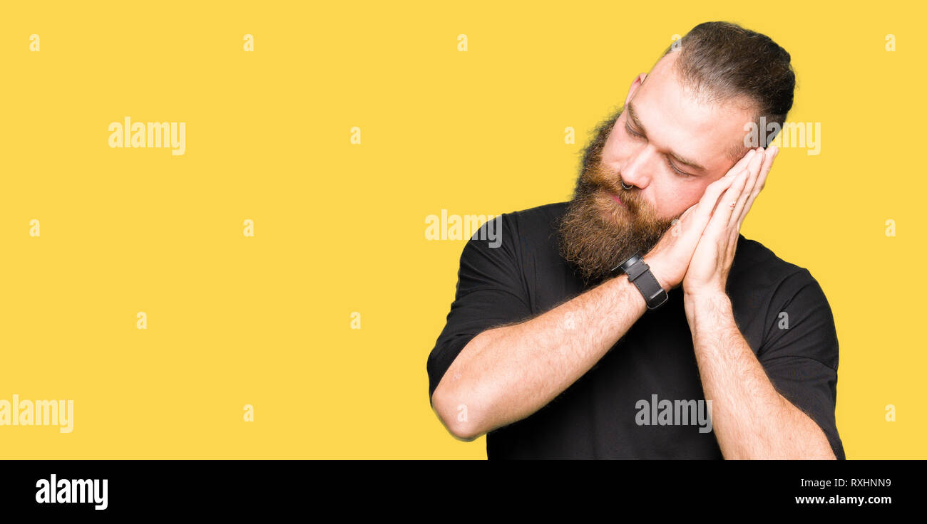 Young blond man wearing casual t-shirt sleeping tired dreaming and ...
