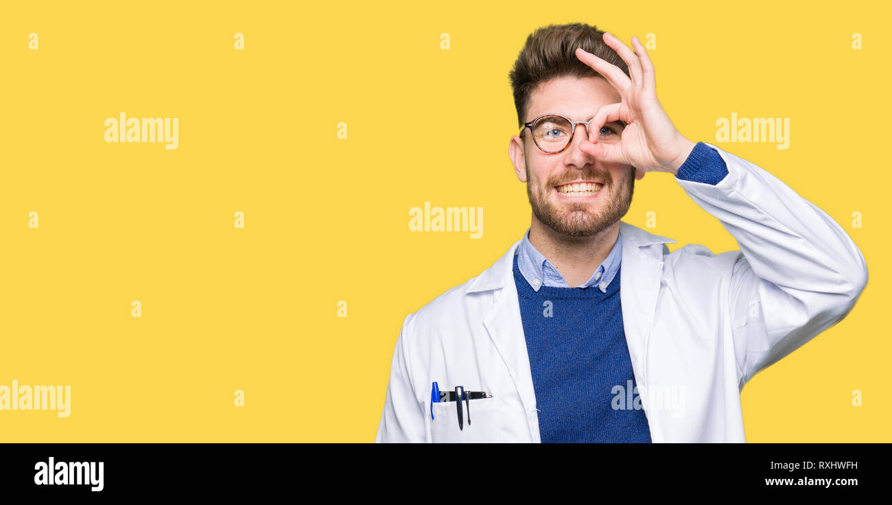 Young handsome scientist man wearing glasses doing ok gesture with hand ...