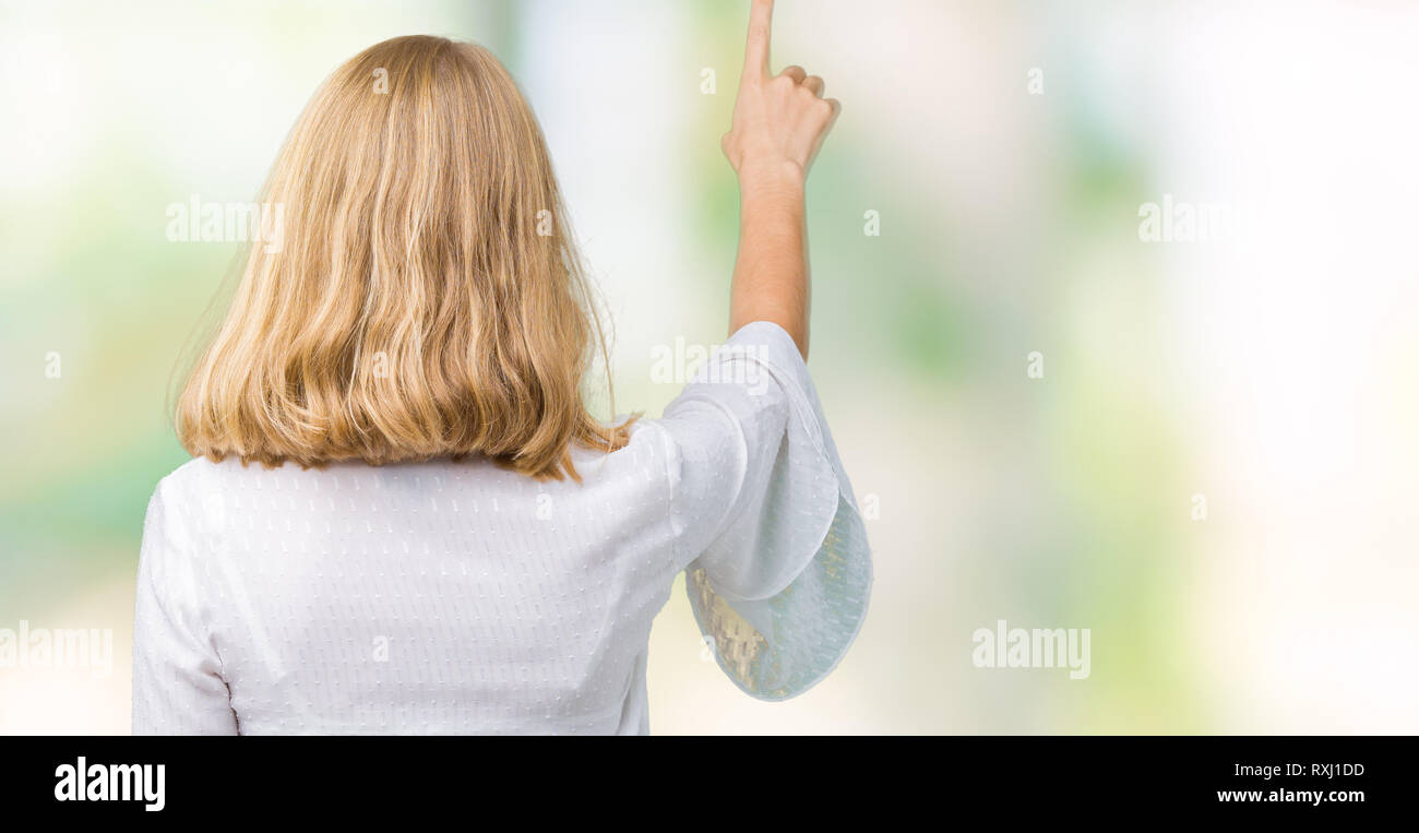 Beautiful young elegant woman over isolated background Posing backwards ...