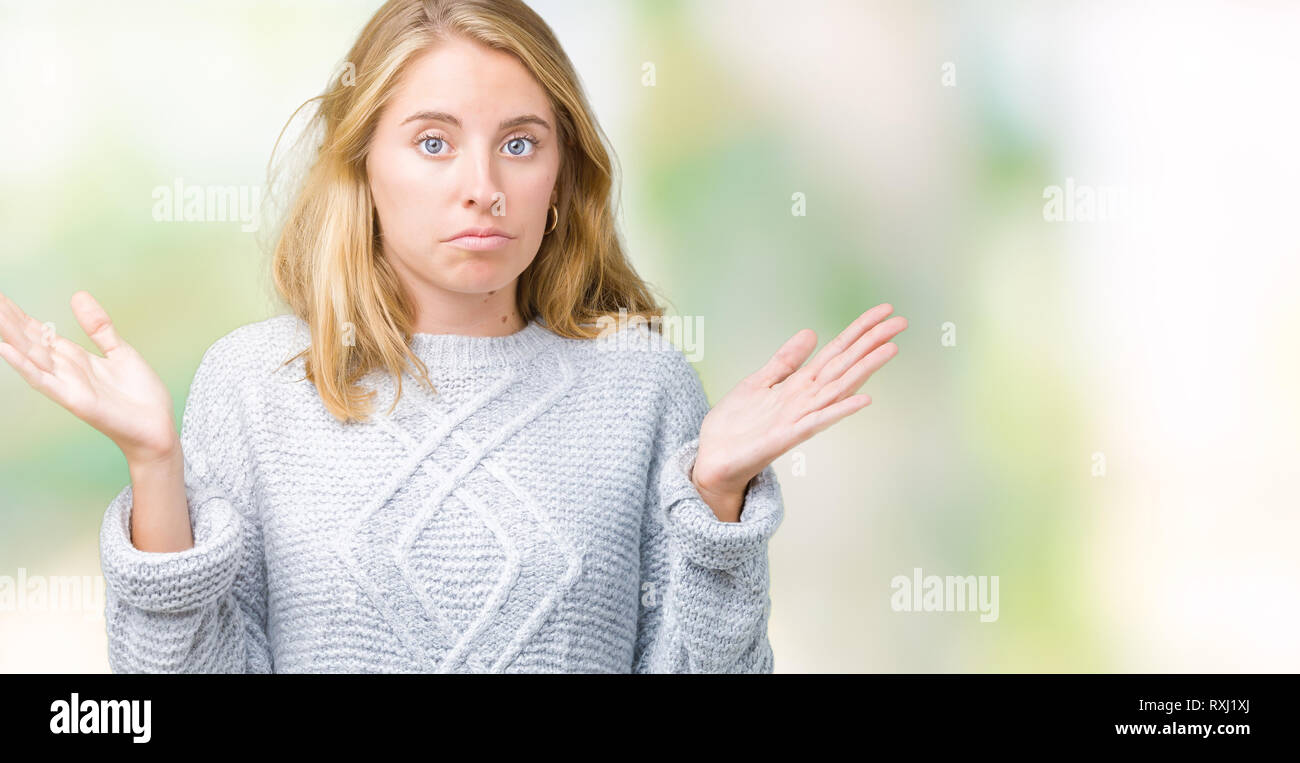 Beautiful young woman wearing winter sweater over isolated background ...