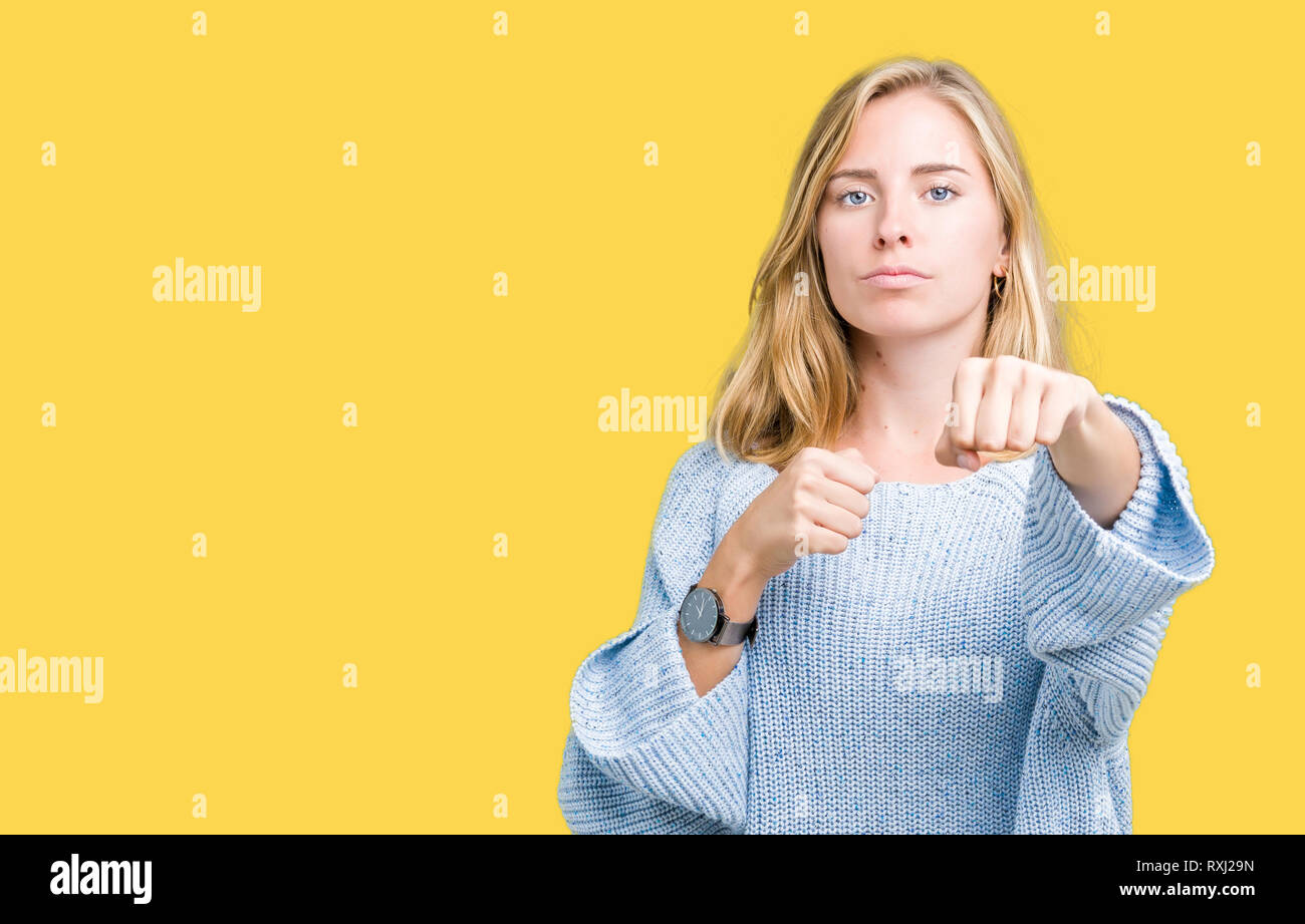 Beautiful young woman wearing blue sweater over isolated background ...