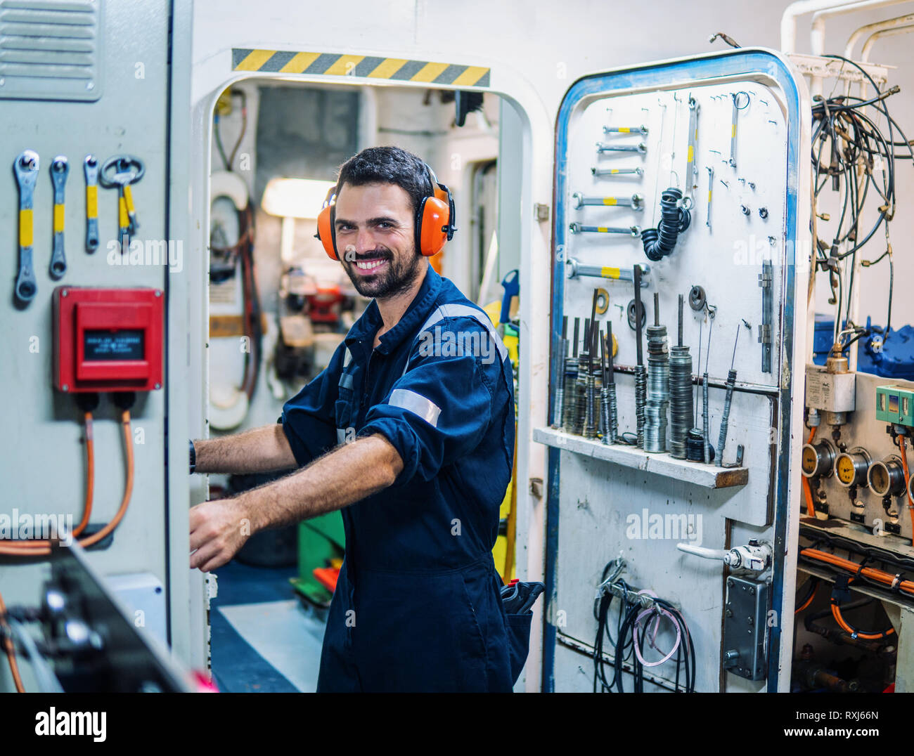 Marine engineer officer working in engine room Stock Photo - Alamy