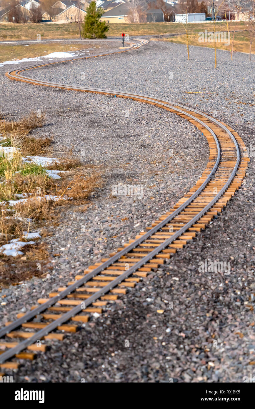 Curving railroad track with homes in the distance Stock Photo - Alamy