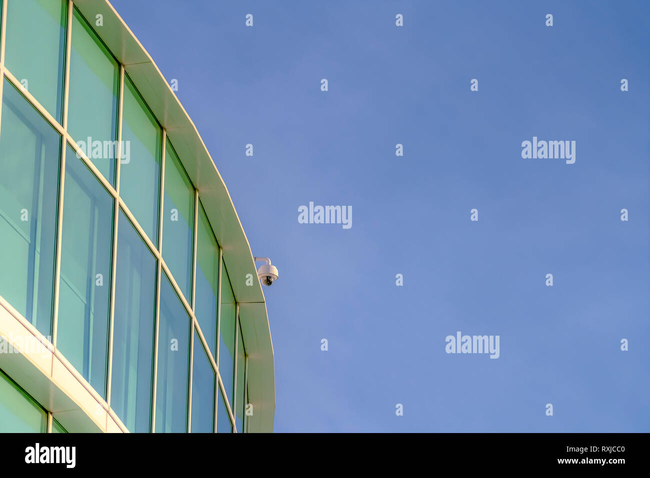 Modern building with surveillance camera on roof Stock Photo - Alamy