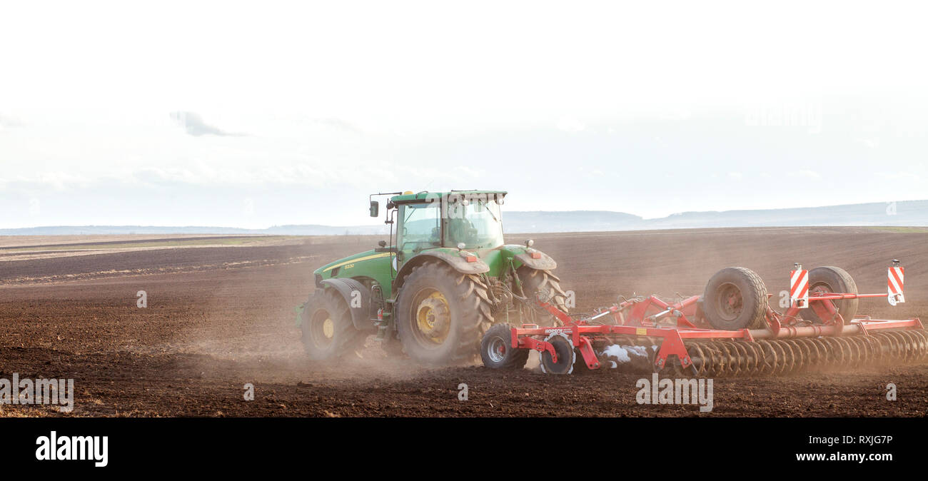 Agriculture,tractor preparing land with seedbed cultivator as part of ...