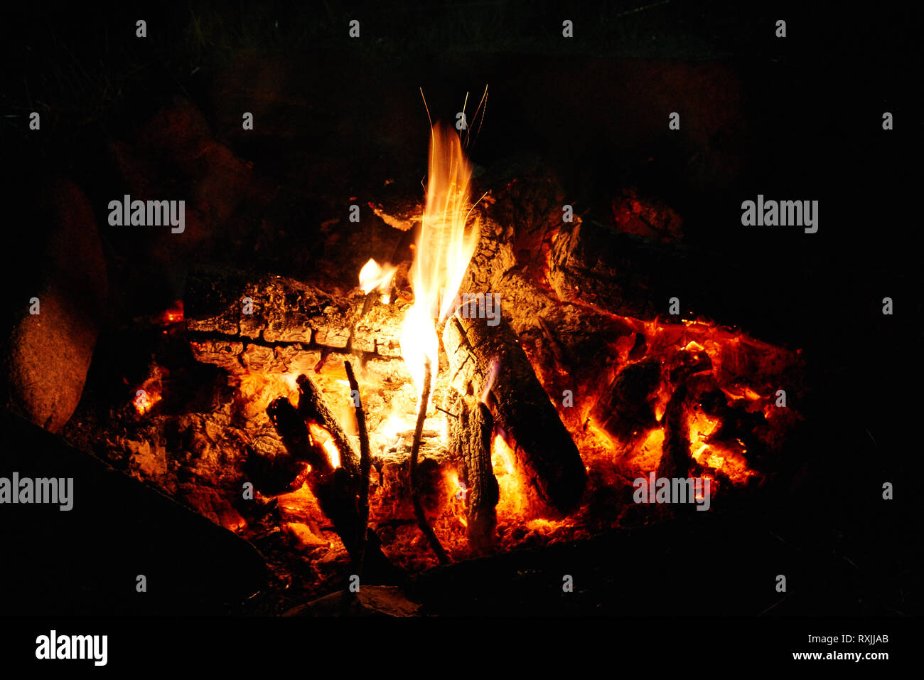 A campfire of several natural logs burns to coals Stock Photo - Alamy