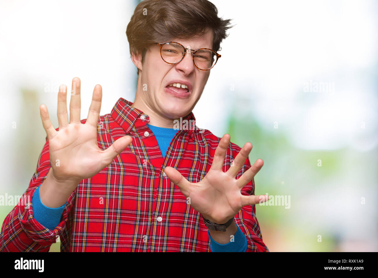 Young handsome man wearing glasses over isolated background afraid and ...