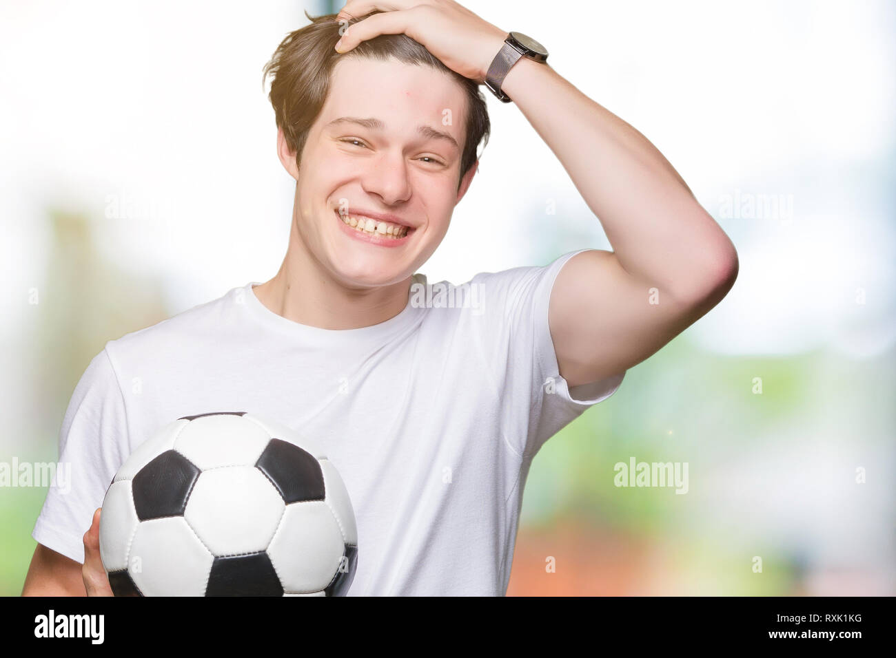 Young man holding soccer football ball over isolated background ...