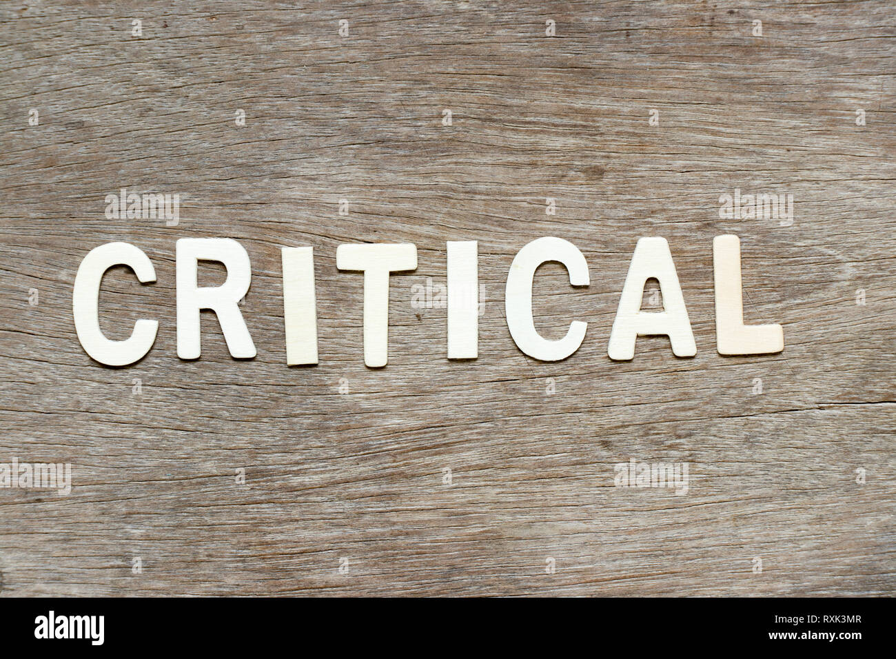 Alphabet letter in word critical on wood background Stock Photo - Alamy