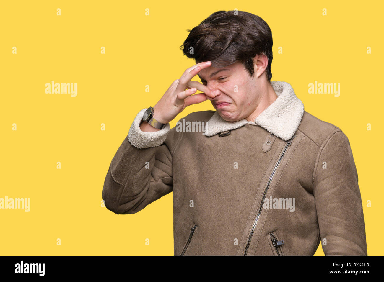 Young handsome man wearing winter coat over isolated background ...