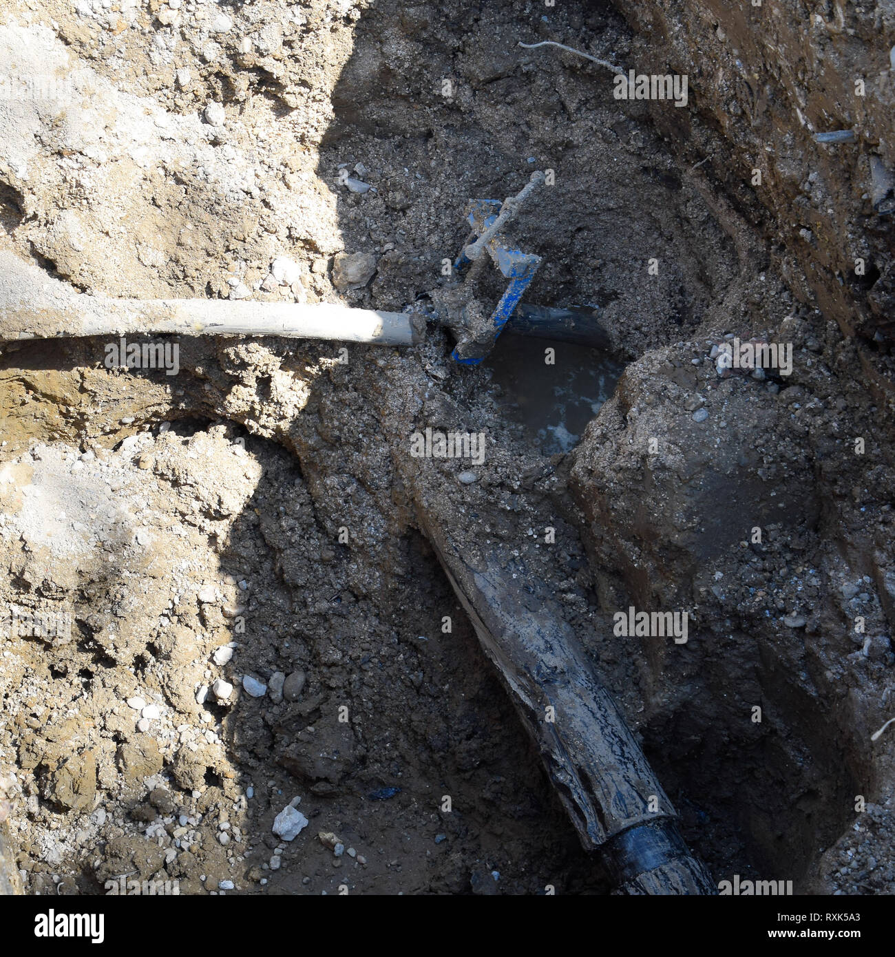 An excavated pit with a damaged pipeline. Repair of communications ...
