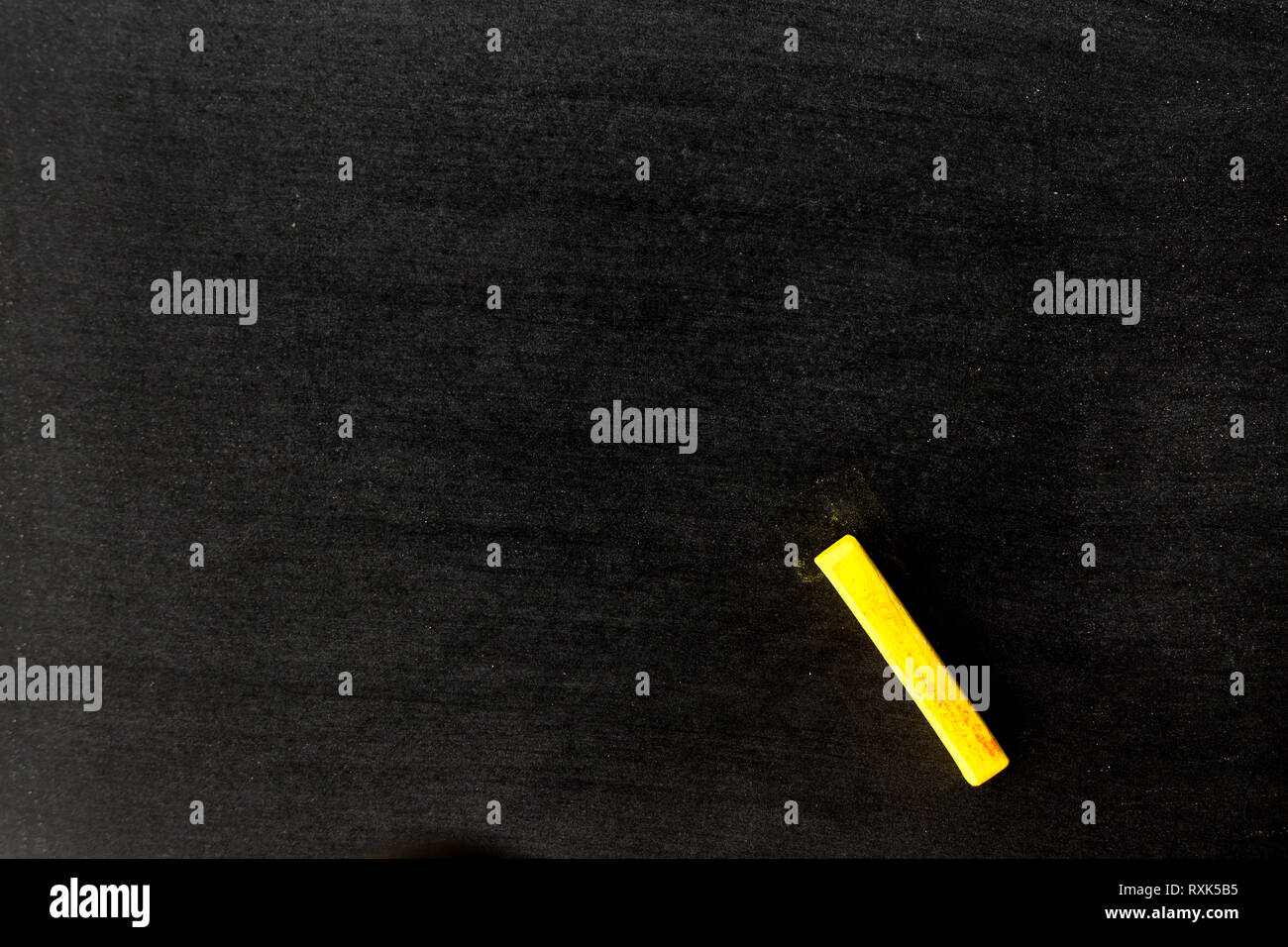 Yellow color chalk on blank blackboard background for decoration or ...