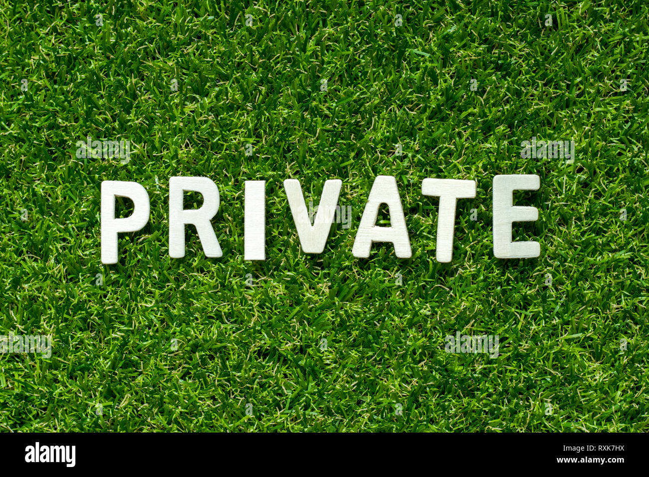 Wood alphabet in word private on artificial green grass background ...