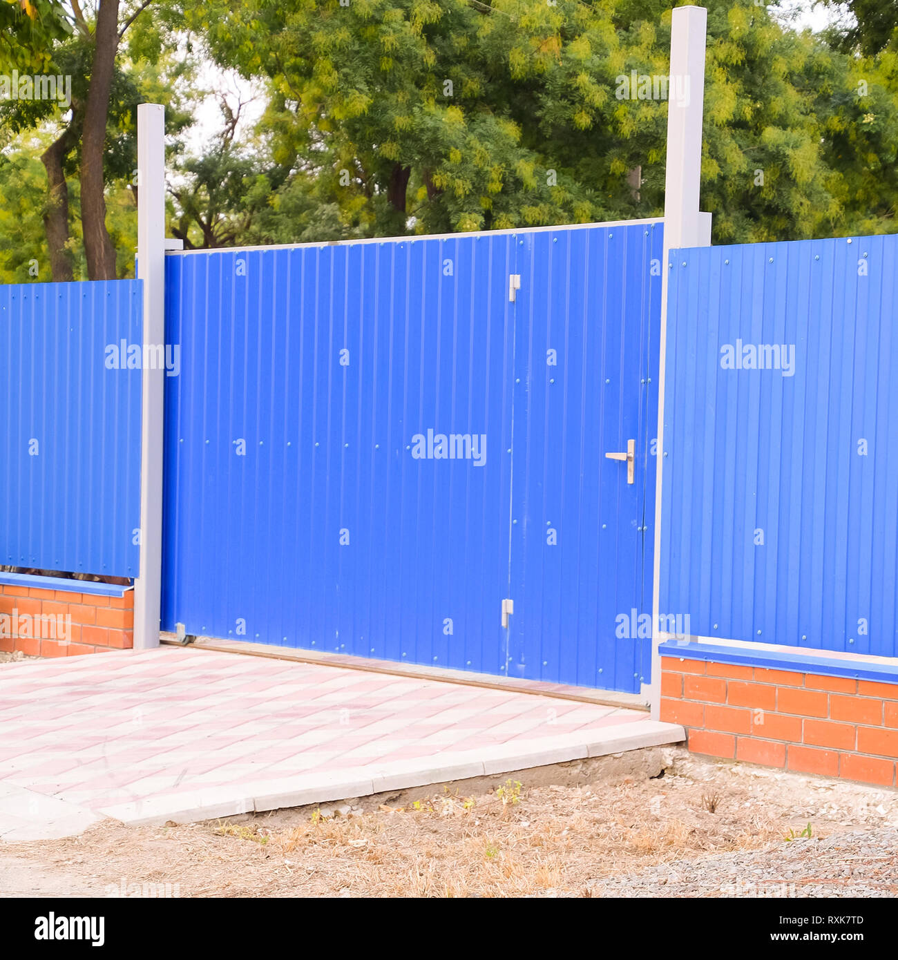 Blue gate and fence. Fence of the private house with blue fence and a ...