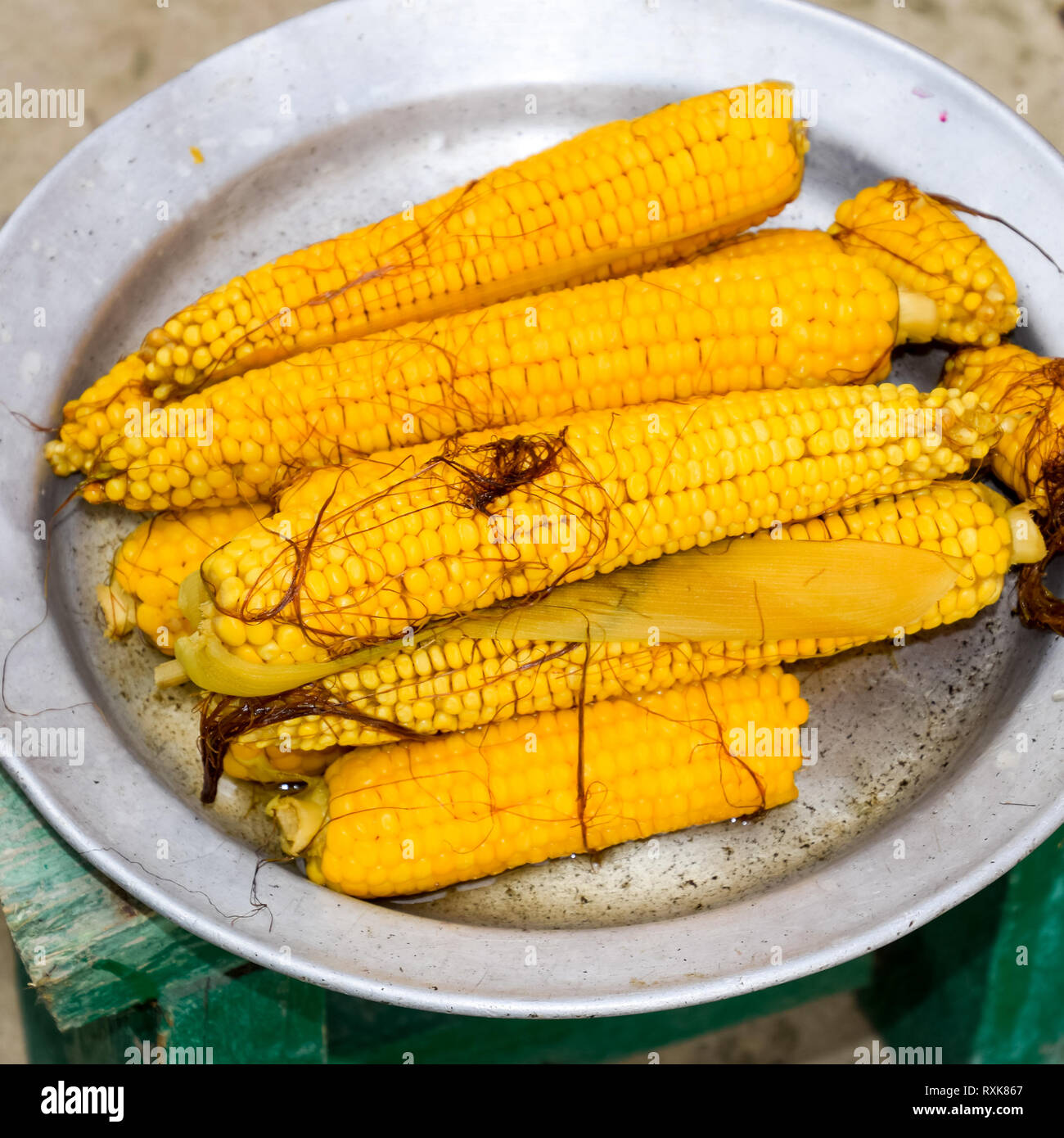 Boiled corn on an aluminum tray. Yellow boiled young corn, useful and ...