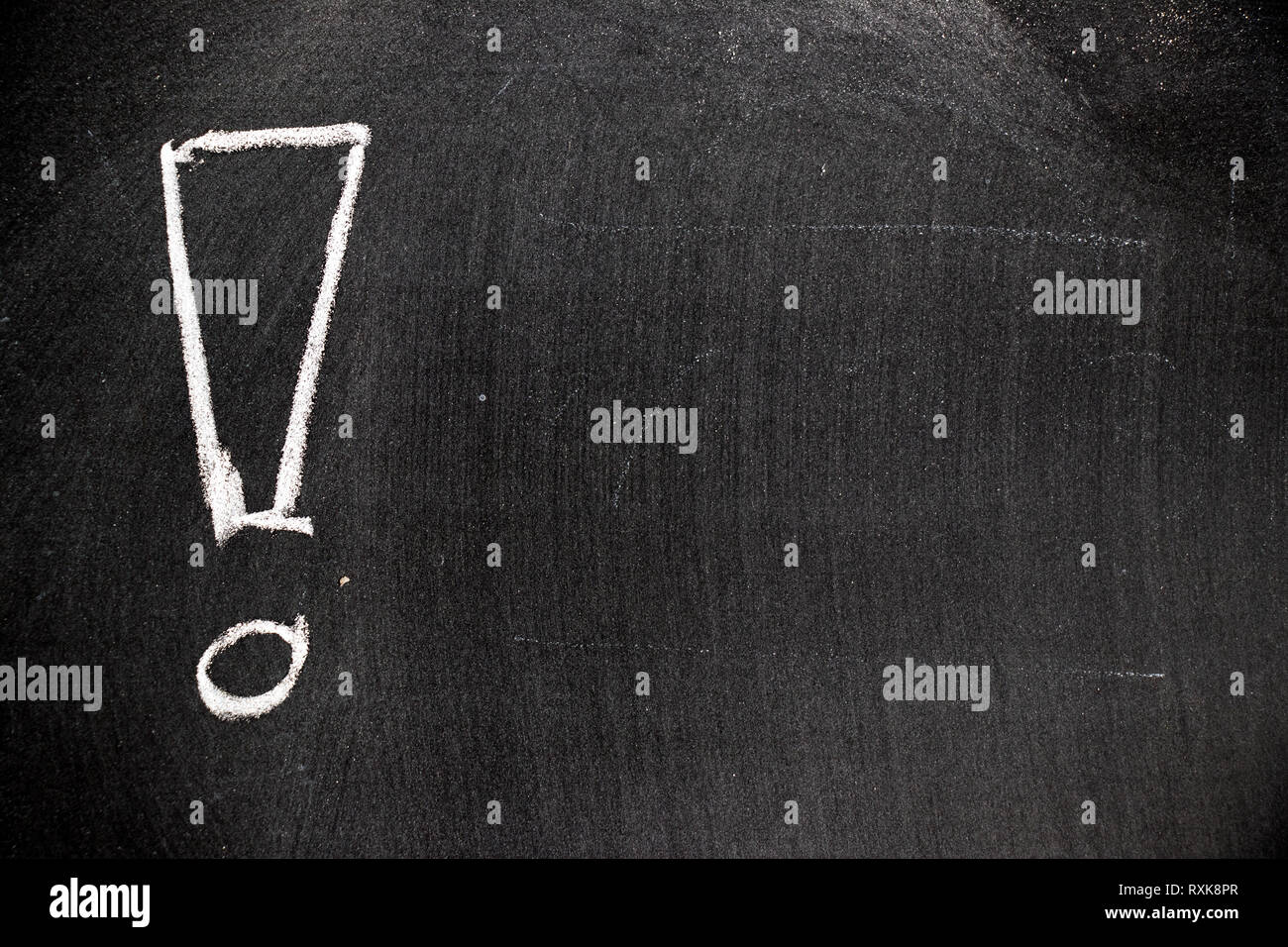 White color chalk hand drawing in exclamation mark with blank space ...