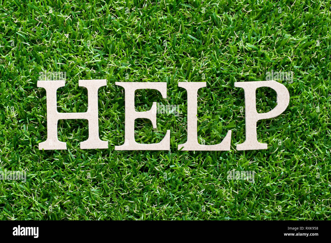 Wood alphabet in word help on artificial green grass background Stock ...