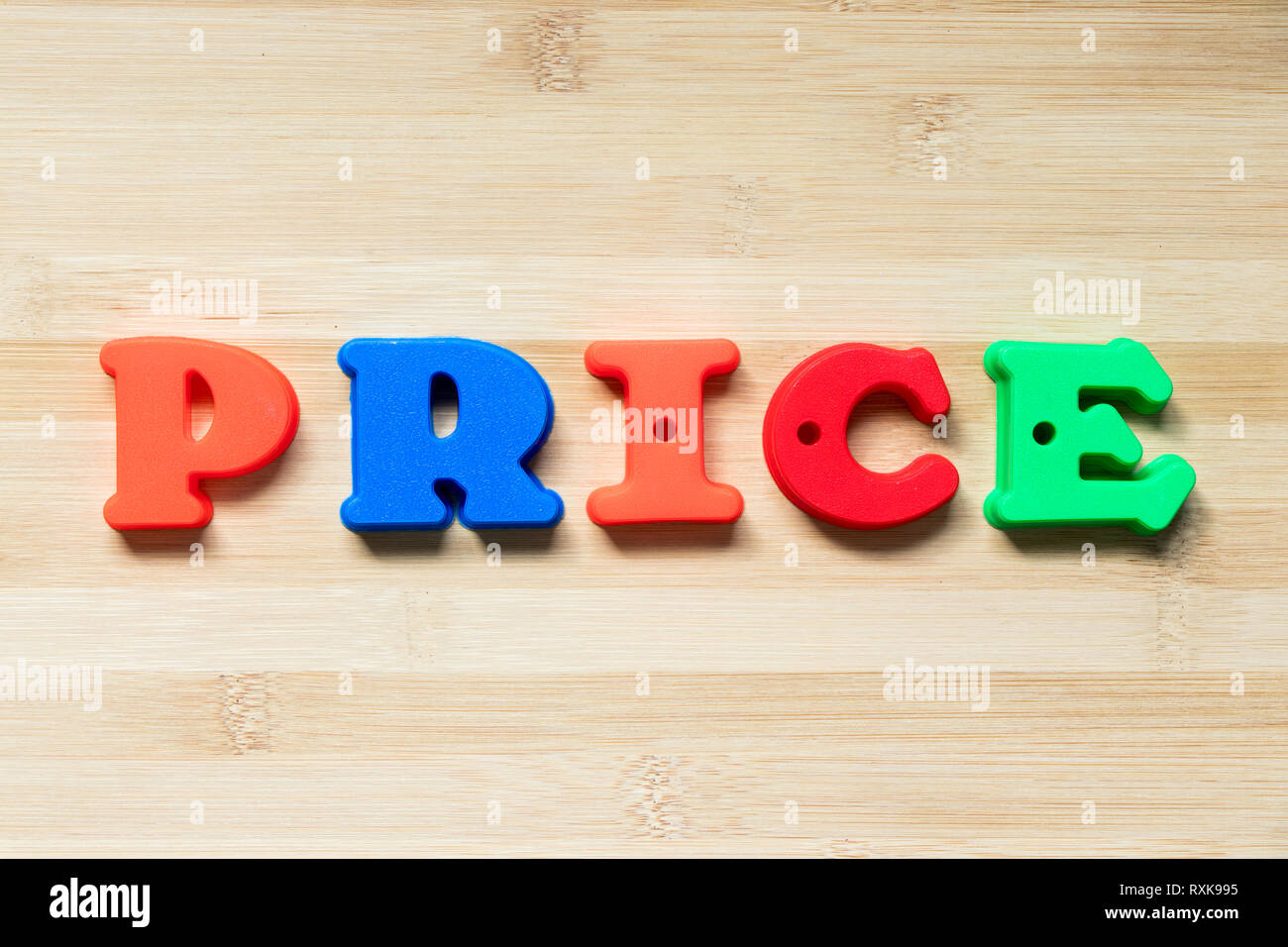 Color plastic alphabet in word price on wood background Stock Photo - Alamy