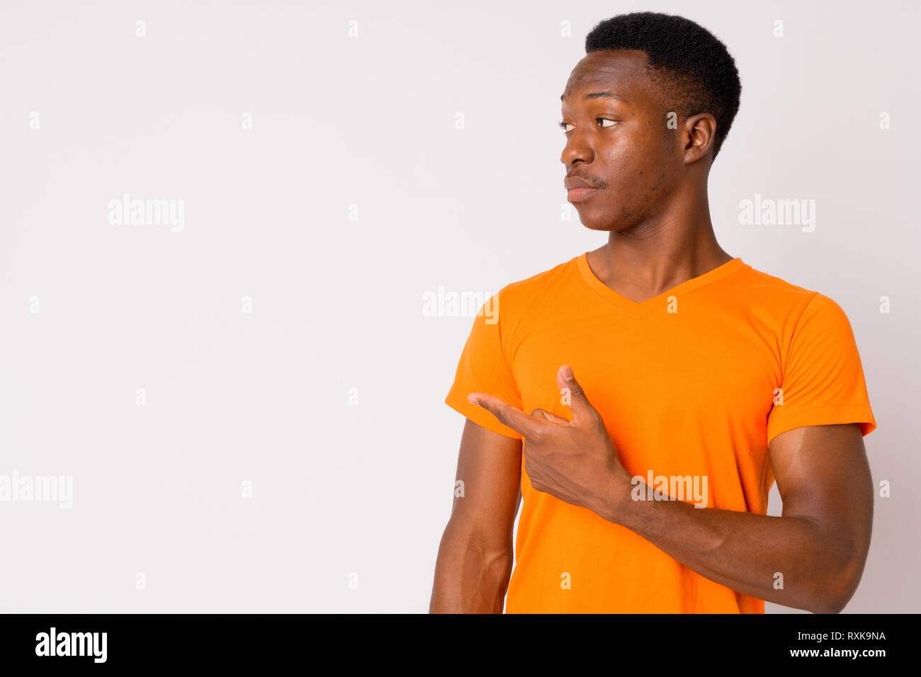 Portrait of young handsome African man thinking and pointing to side ...