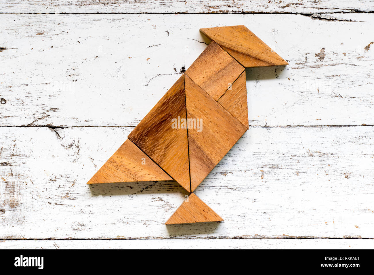 Tangram puzzle in bird shape on old white wood background Stock Photo ...