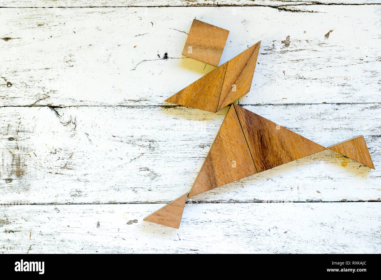 Tangram puzzle in happy running man shape on old white wood background ...